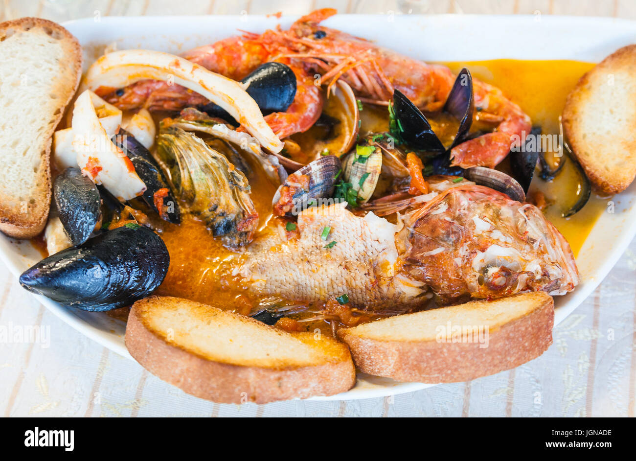 typical italian food - top view of bowl with fish soup with seafood in ...