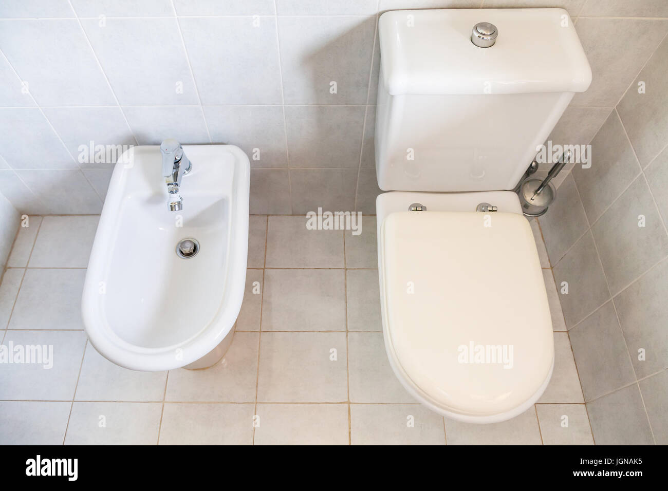 above view of white toilet with bowl drain and bidet in toilet room ...