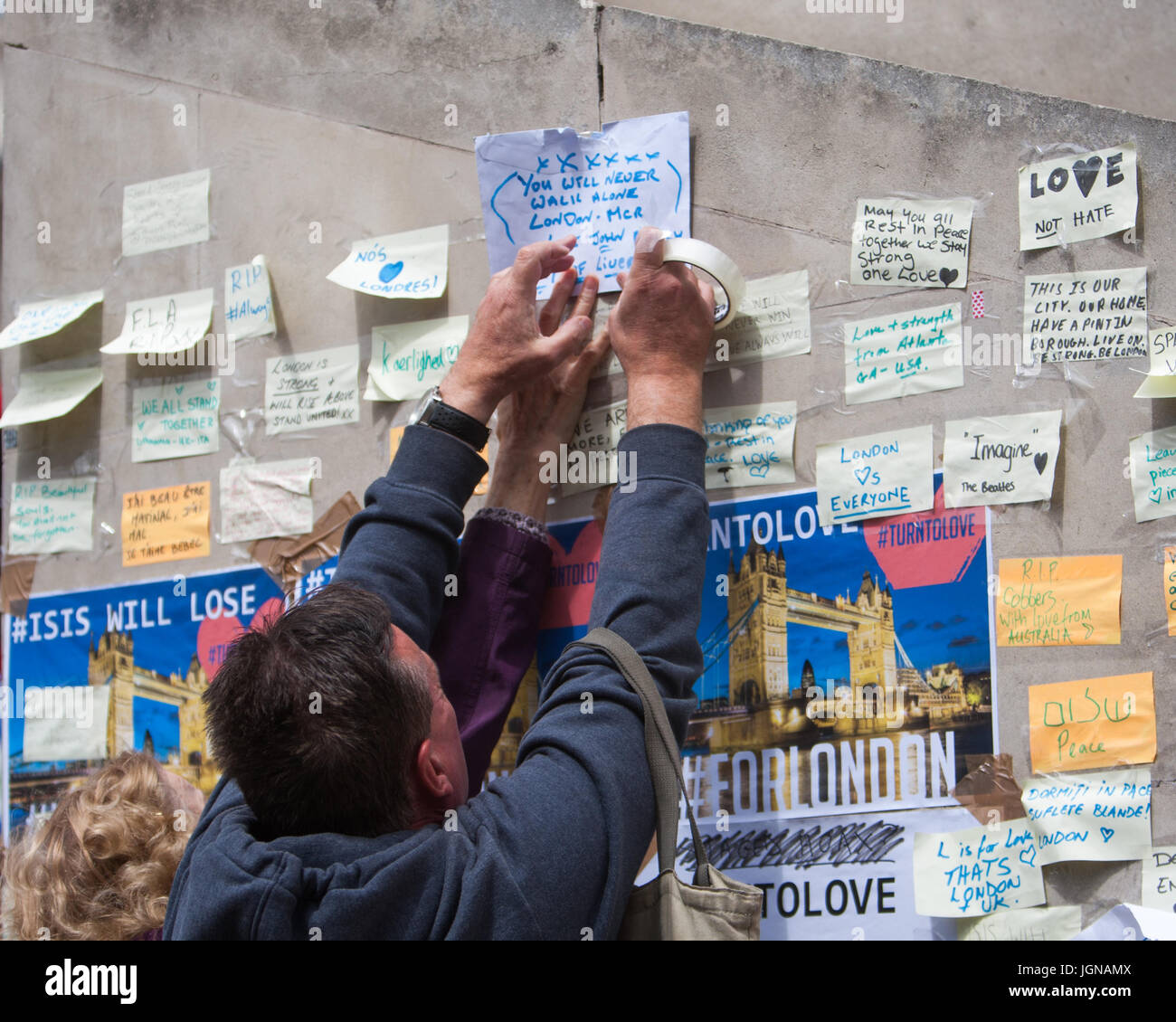 People reading & writing post it note tributes at London Bridge for the ...