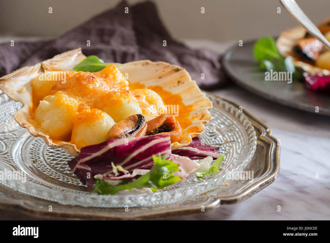 Gnocchi pasta with mussels, tomato and cream room, in vieira shell ...