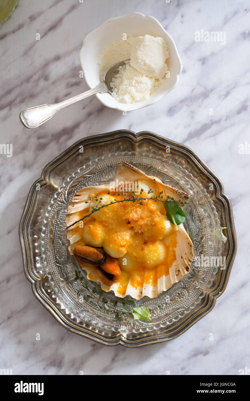 Gnocchi pasta with mussels, tomato and cream room, in vieira shell ...