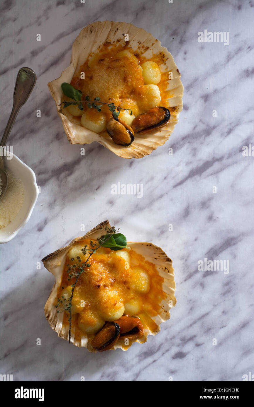 Gnocchi pasta with mussels, tomato and cream room, in vieira shell ...