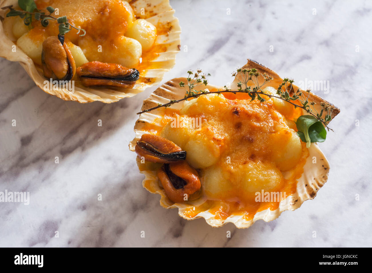 Gnocchi pasta with mussels, tomato and cream room, in vieira shell ...