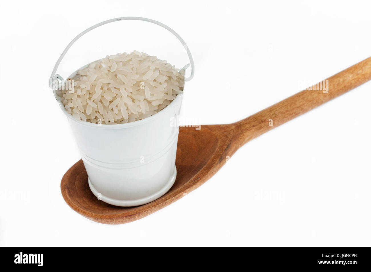 Full bucket of rice grains stands in a wooden spoon. The concept of ...