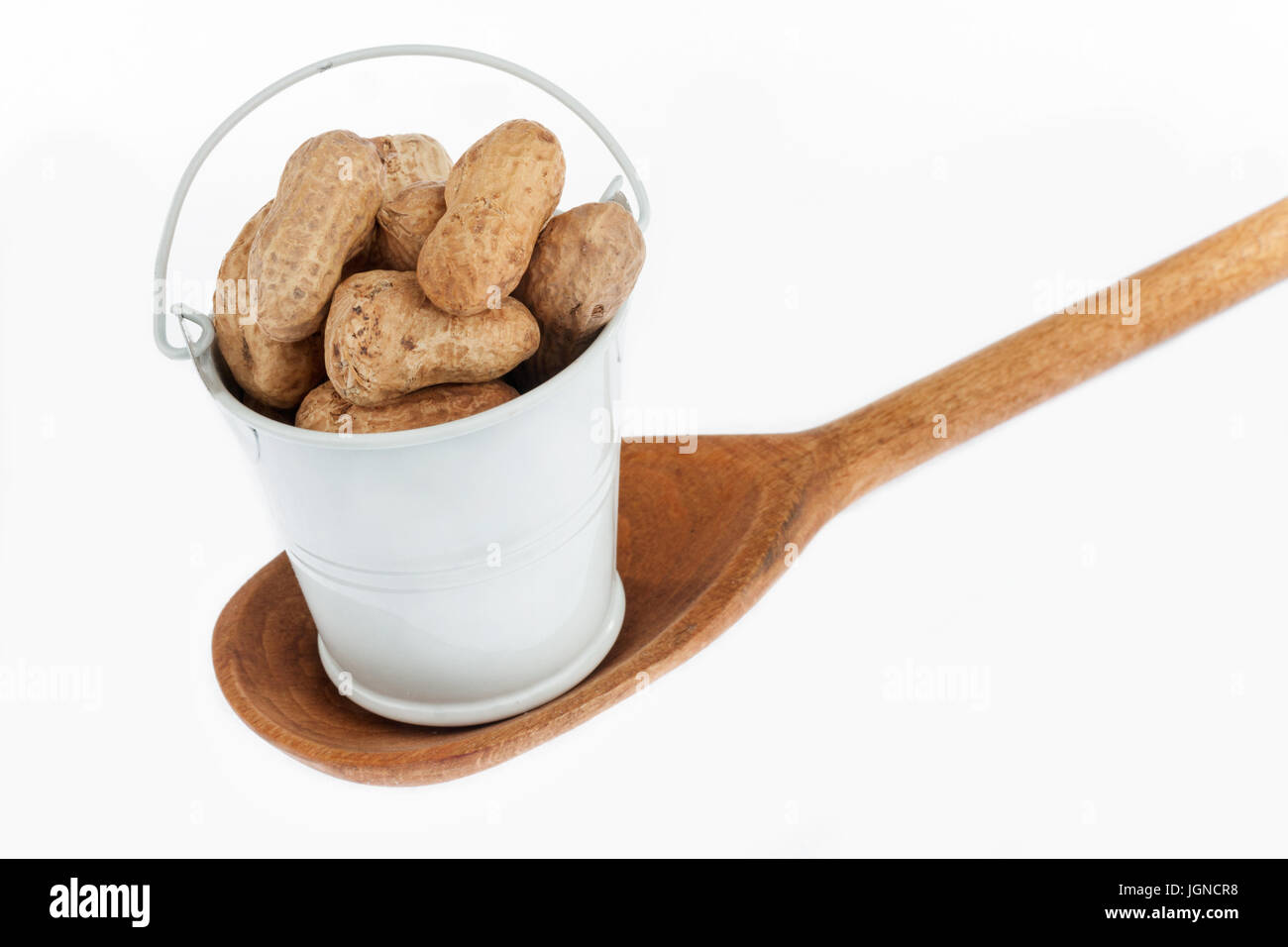 Full bucket of peanut stands in a wooden spoon. The concept of food ...