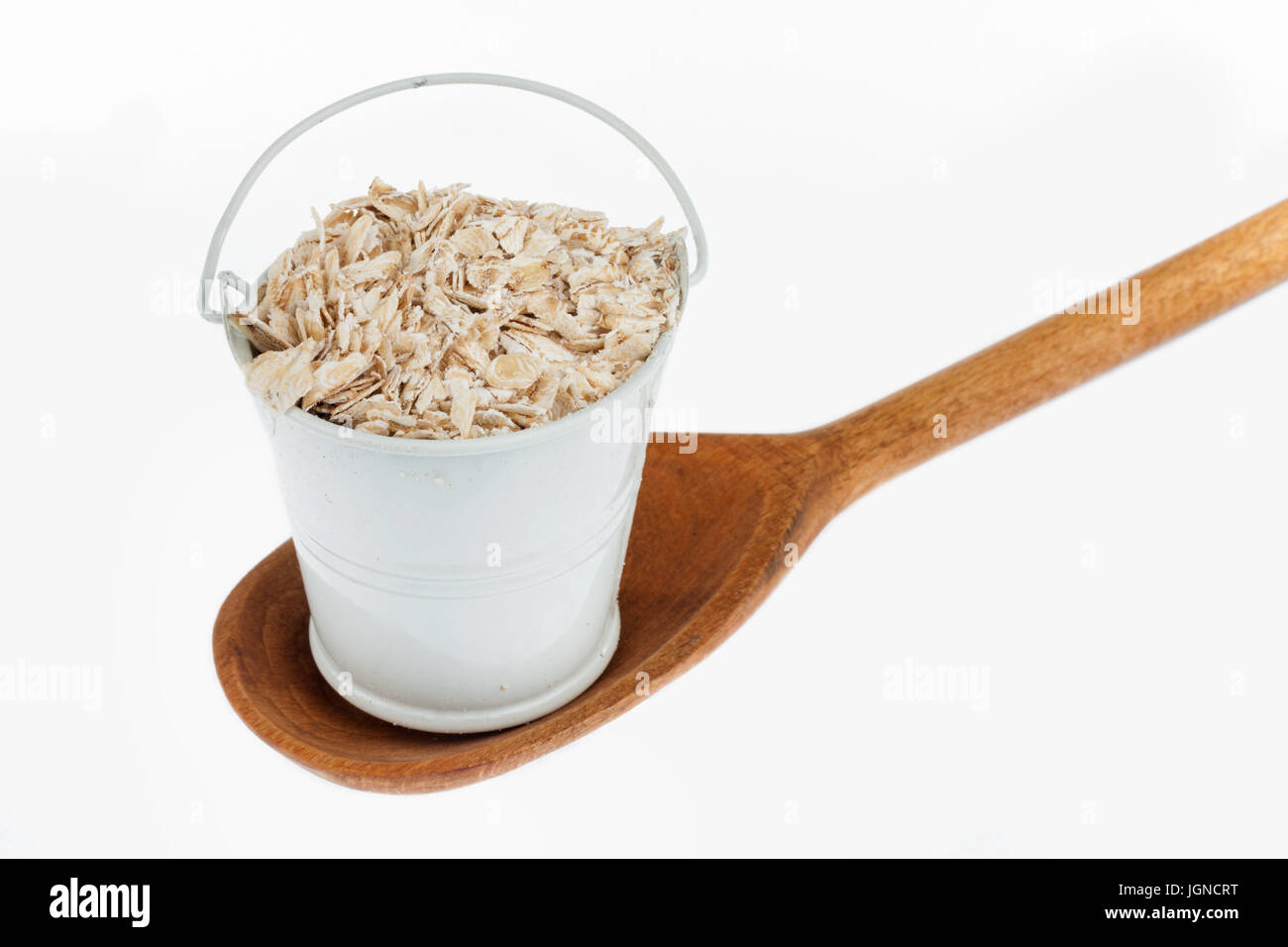 Full bucket of oat flakes stands in a wooden spoon. The concept of food ...