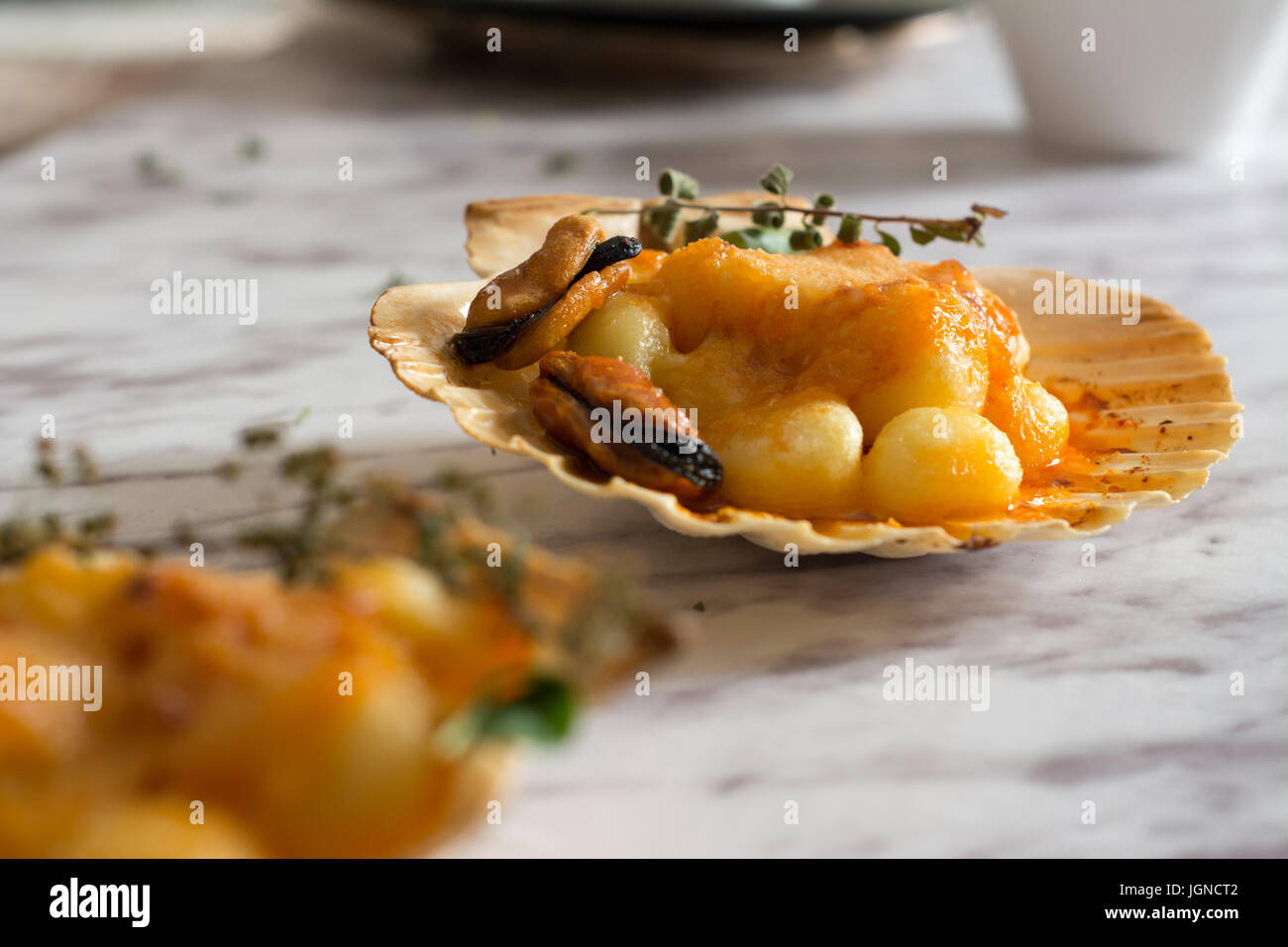 Gnocchi pasta with mussels, tomato and cream room, in vieira shell ...