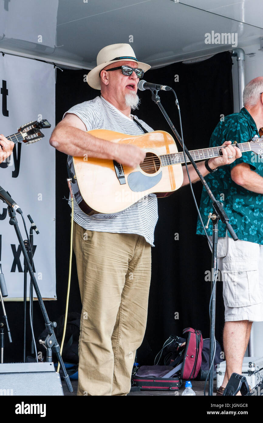 Crisis 4 on stage with singer Chris Sadler standing singing. Mature man ...