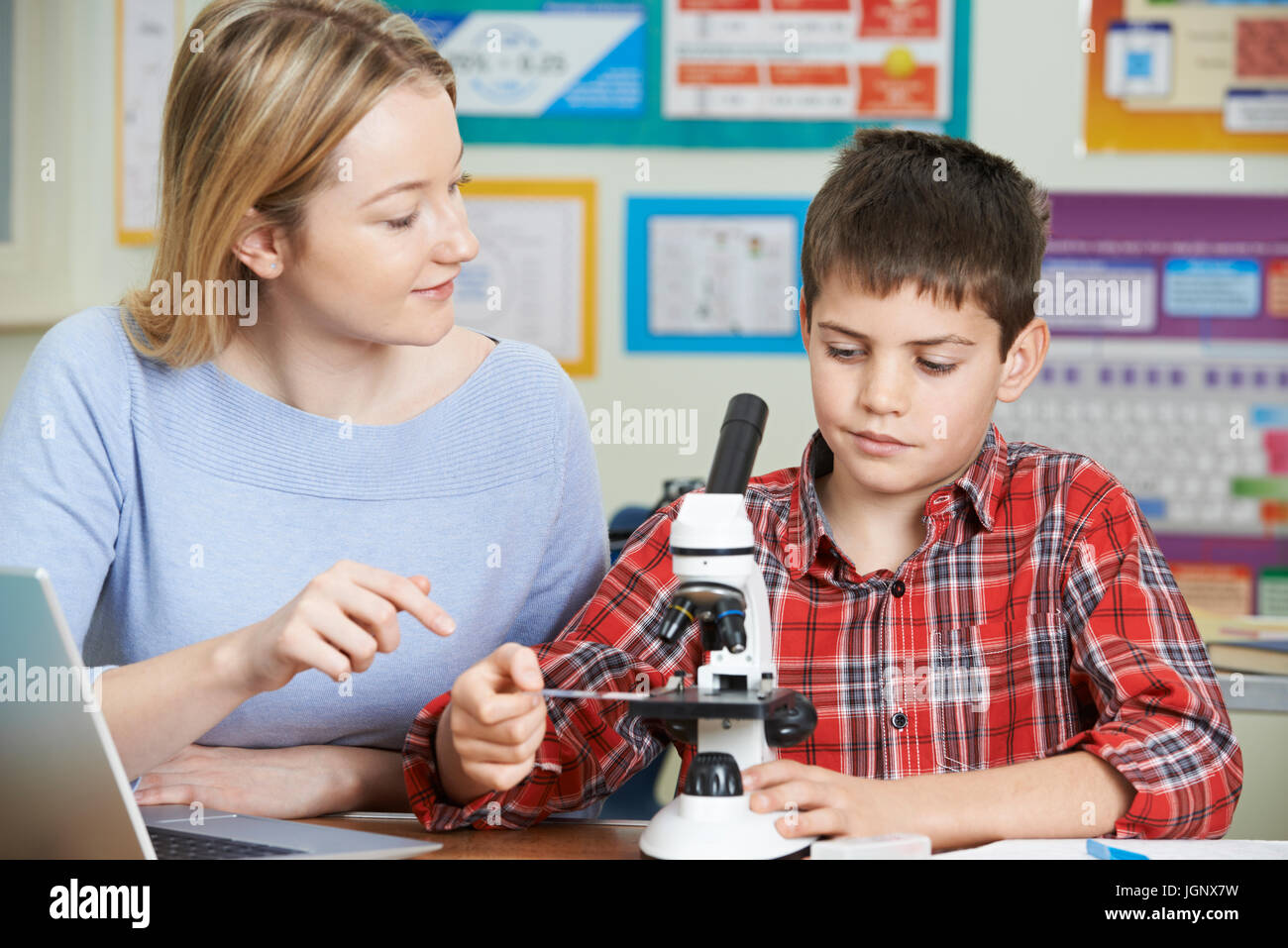 Teacher With Male Student Using Microscope In Science Class Stock Photo ...