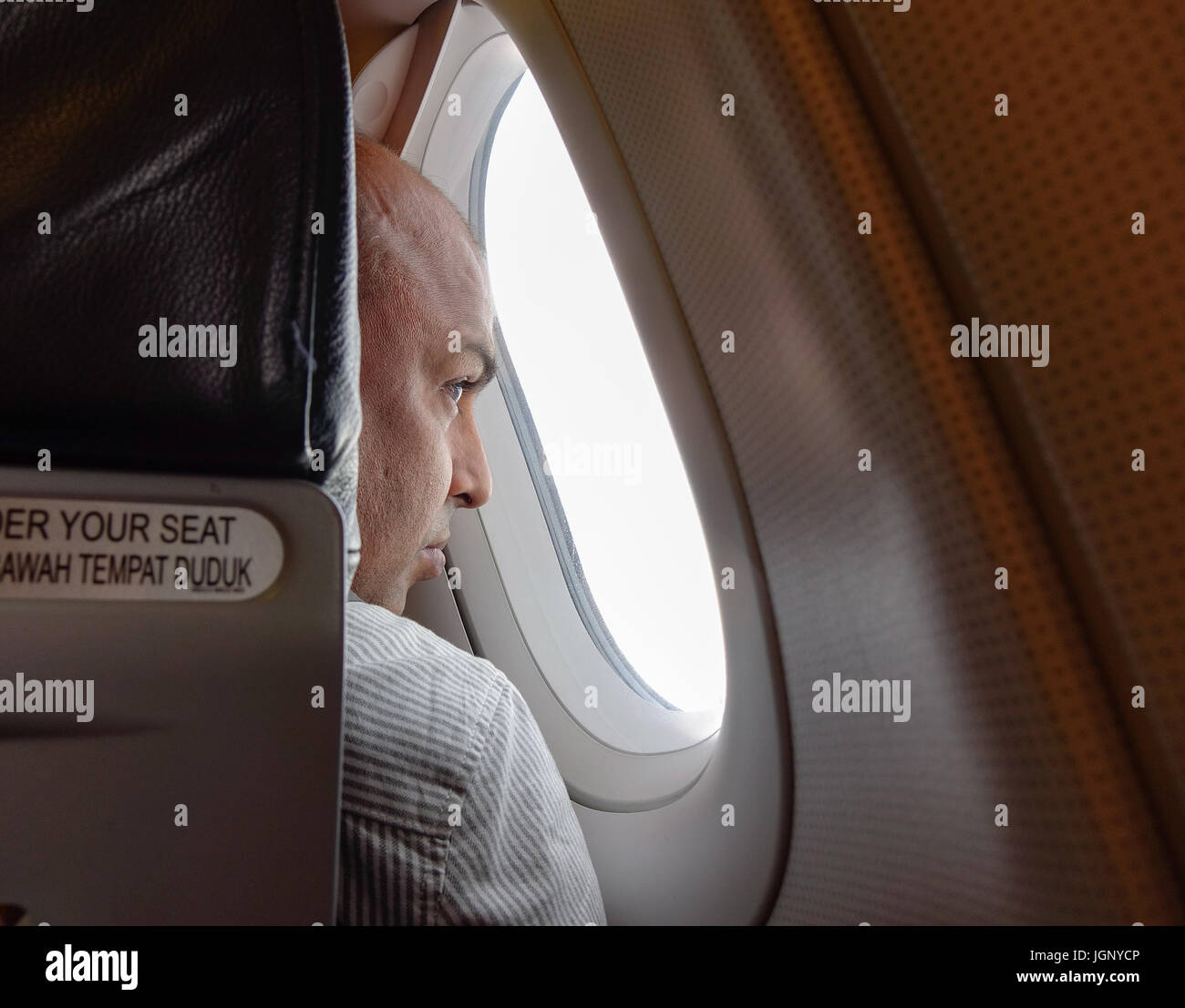Kuala Lumpur, Malaysia - Dec 16, 2015. A man sitting inside an airplane ...