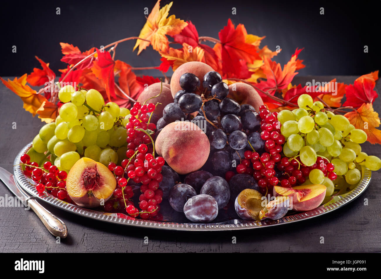 Autumn fruits in a tray on dark background Stock Photo - Alamy