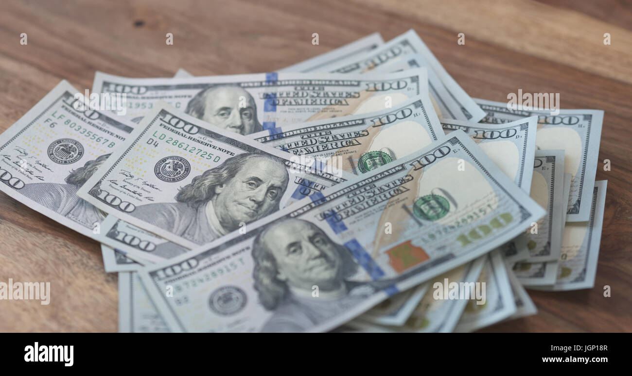 hundred dollar bills on wood table Stock Photo - Alamy