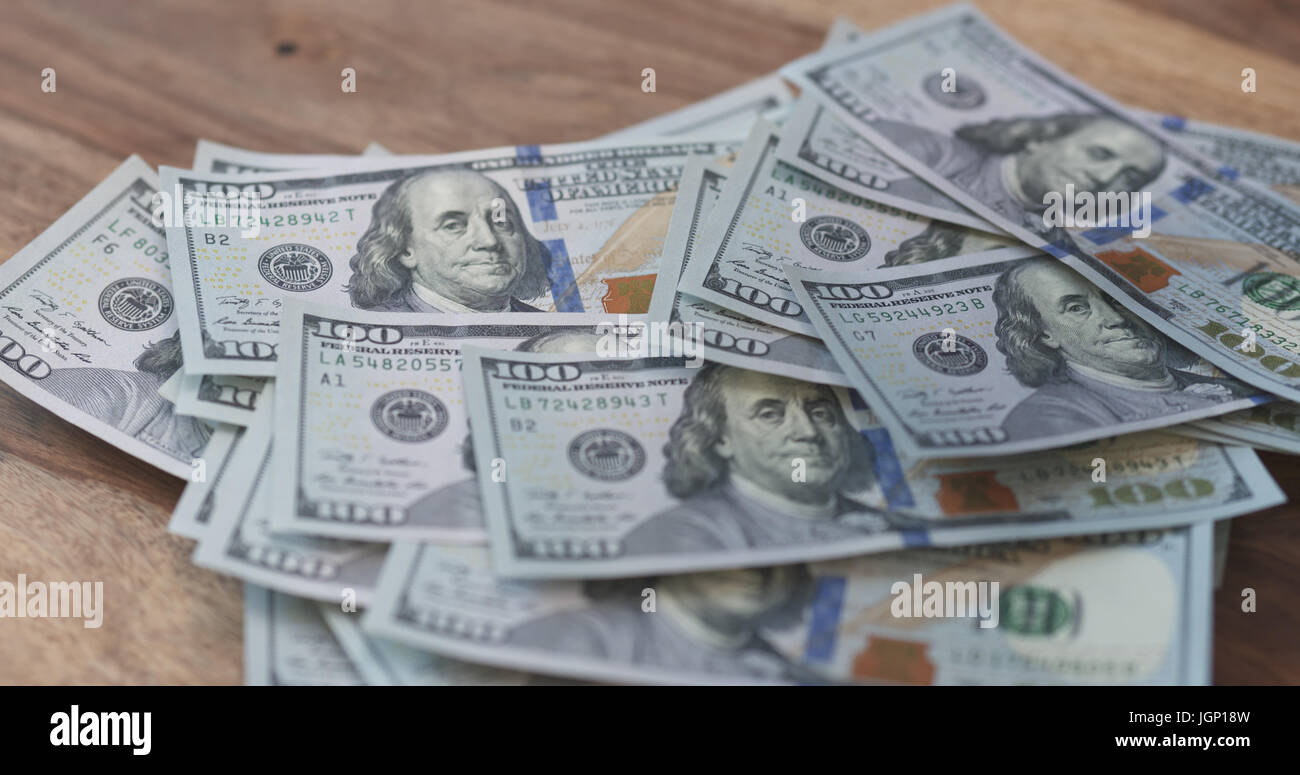 hundred dollar bills on wood table Stock Photo - Alamy