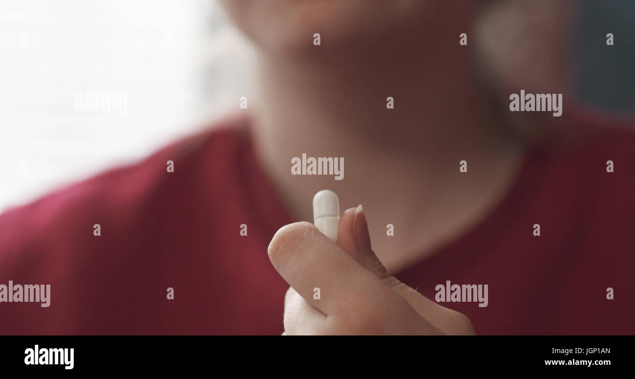 handheld teen girl taking pill Stock Photo - Alamy
