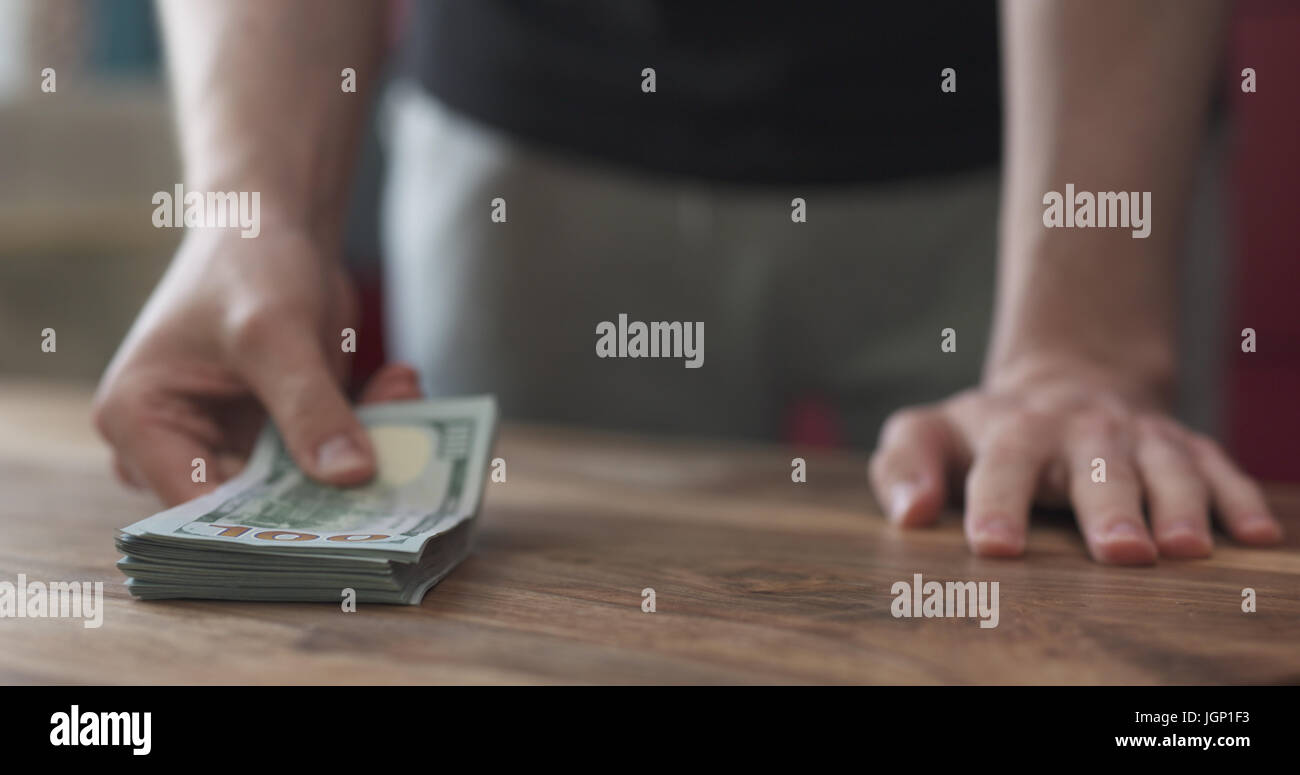 front shot of man counting dollars on wood table Stock Photo - Alamy