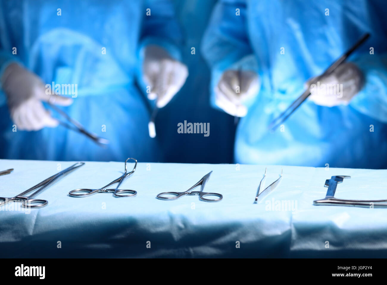 Surgical tools lying on the table while group of surgeons at background ...