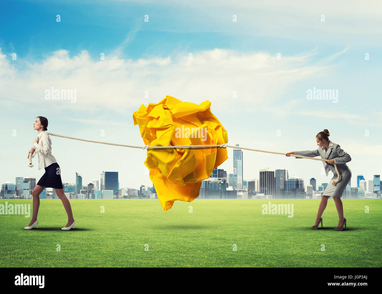 Two women pulling with effort big crumpled ball of paper as creativity ...