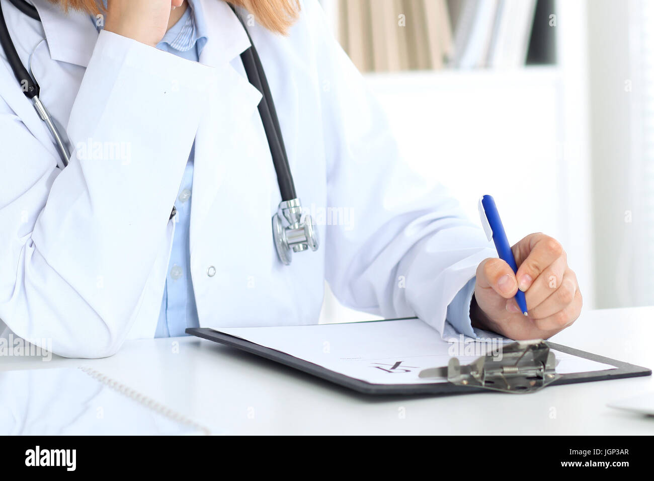 Close up of a female doctor writing a medical prescription, just hands ...