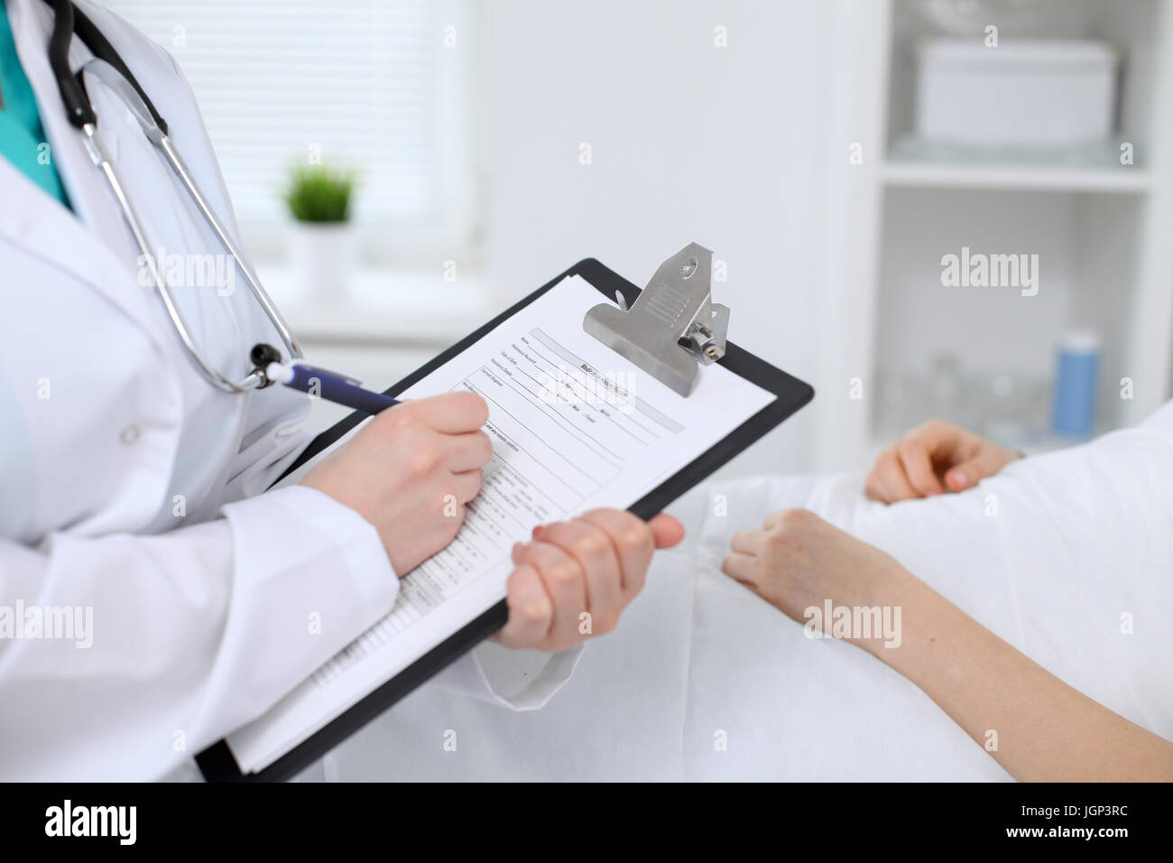 Close-up of a female doctor holding application form while consulting ...