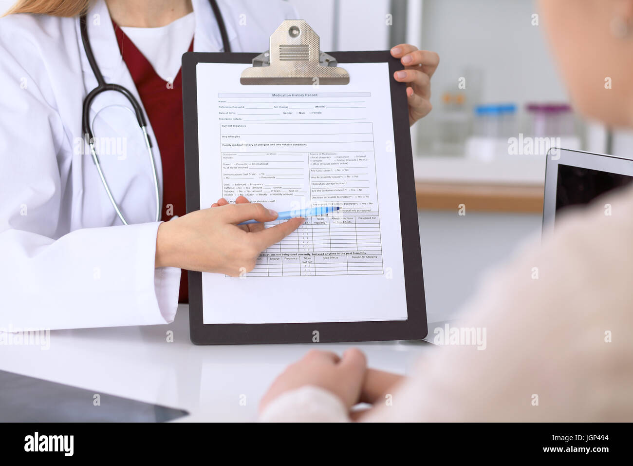 Close up of a female doctor pointing into an application form while ...