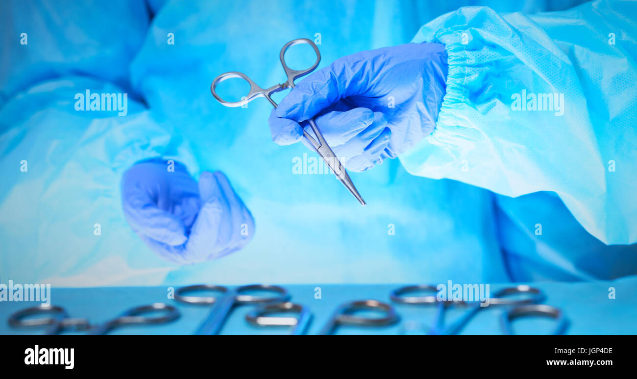Close-up of of surgeons hands at work in operating theater toned in ...