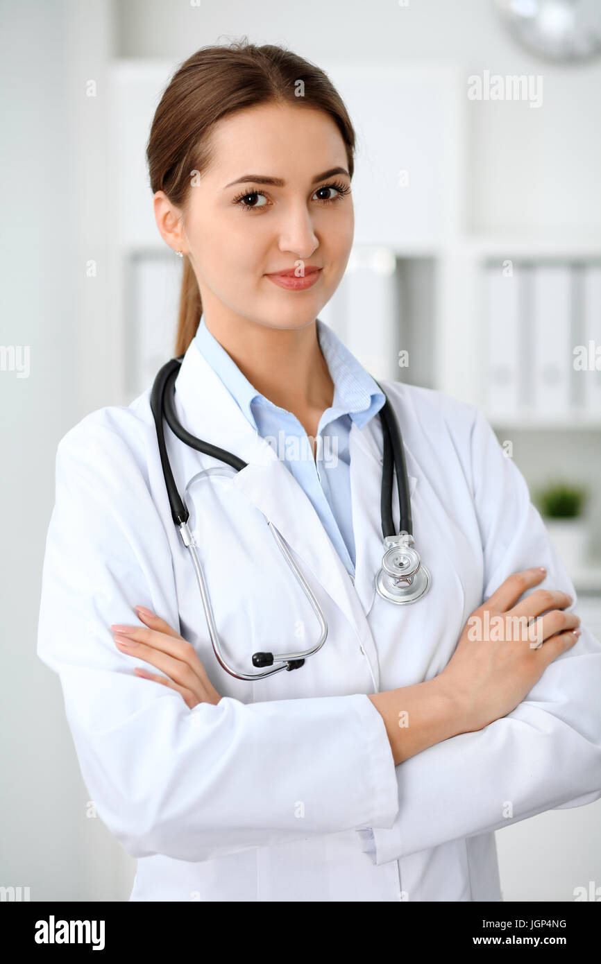 Latin american doctor woman standing with arms crossed and smiling at ...