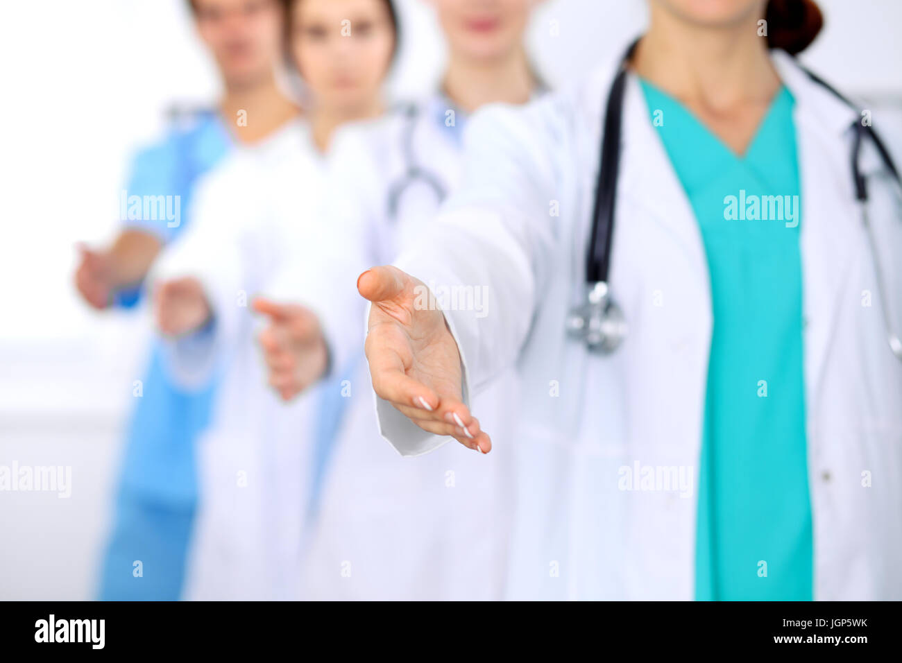 Group of doctors offering helping hand in hospital closeup. Friendly ...