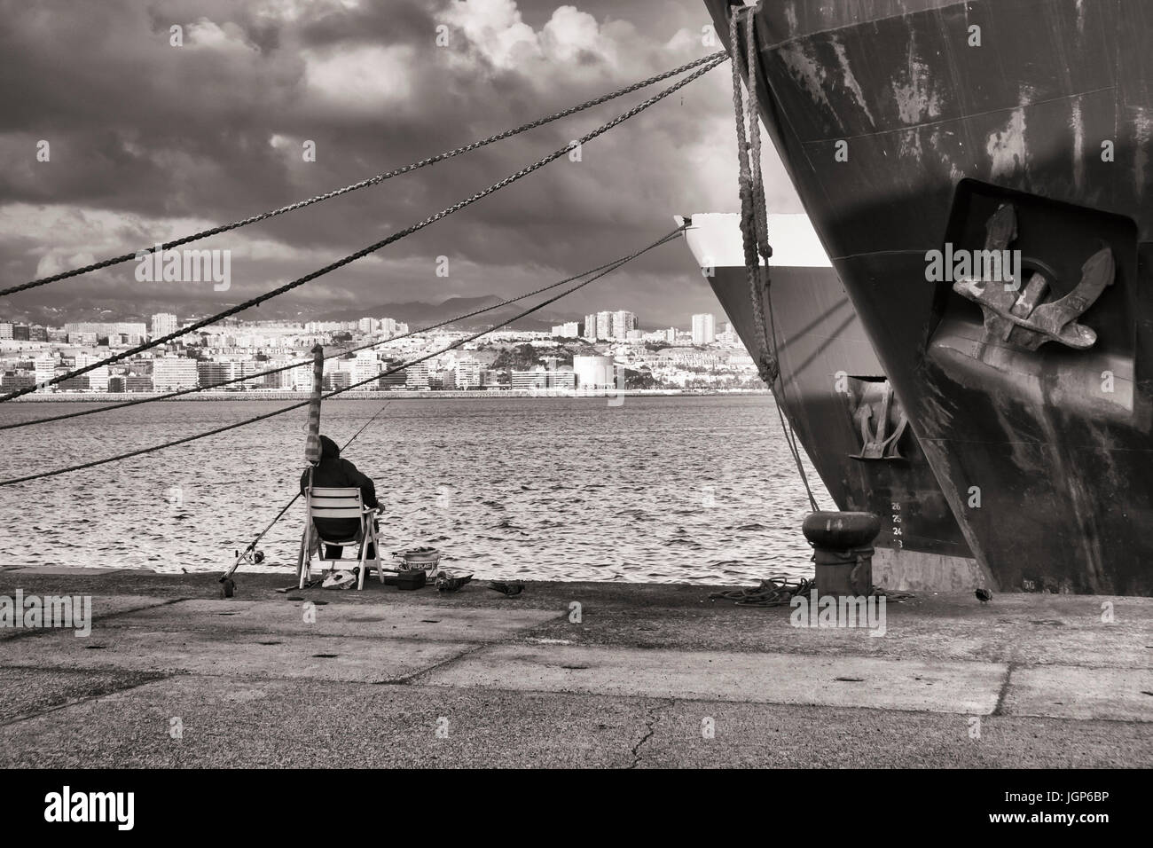 Elderly man fishing near rusting trawlers in Spanish port Stock Photo ...