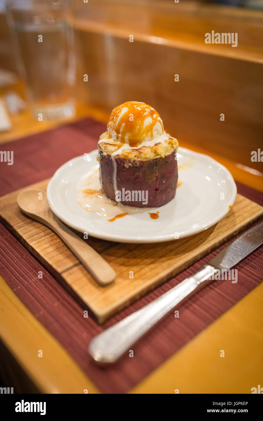 Baked yam topped with vanilla ice cream and caramel Stock Photo - Alamy