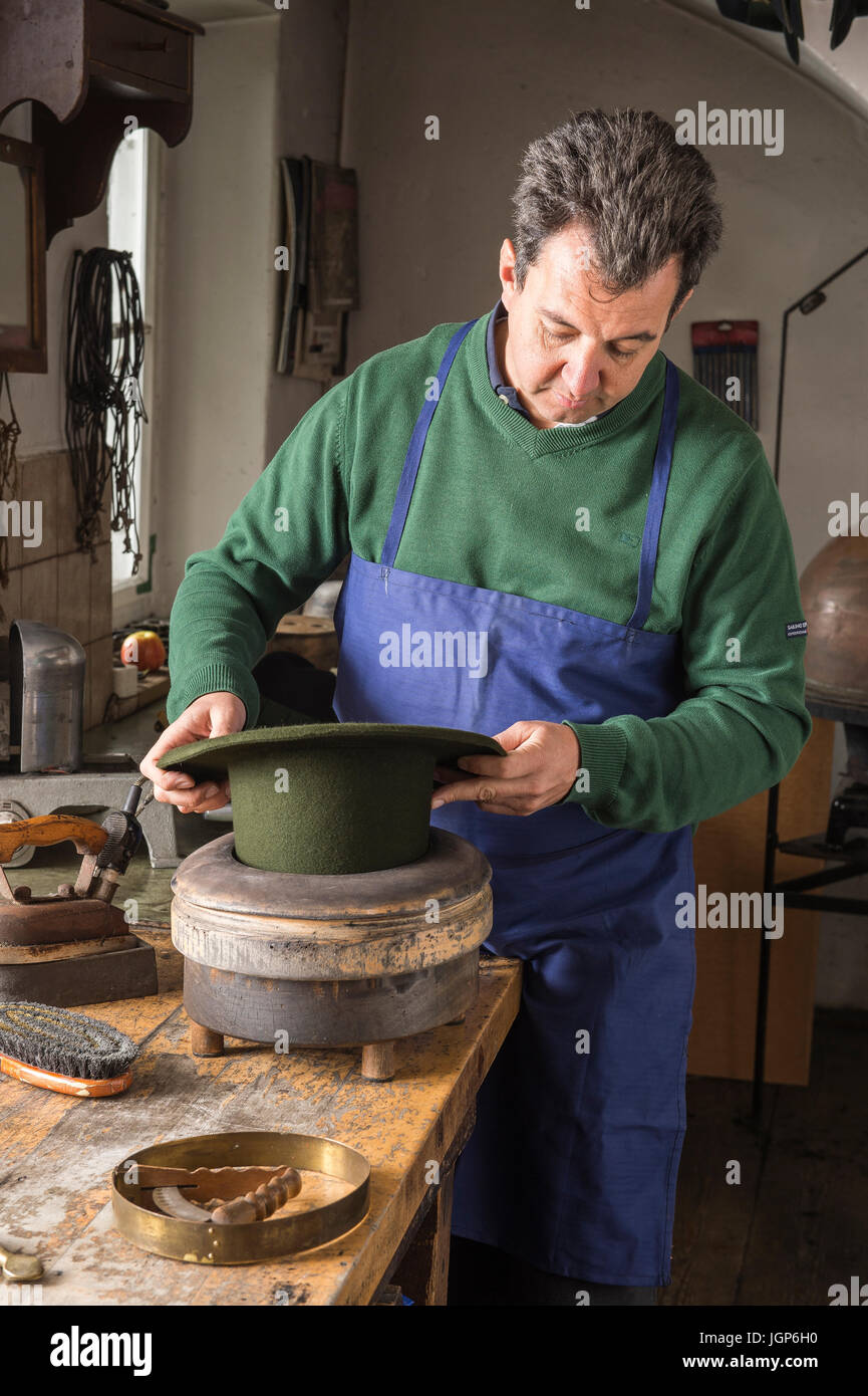 Hatter pushing dry wool felt hat into edge mold, hatmaker workshop, Bad ...