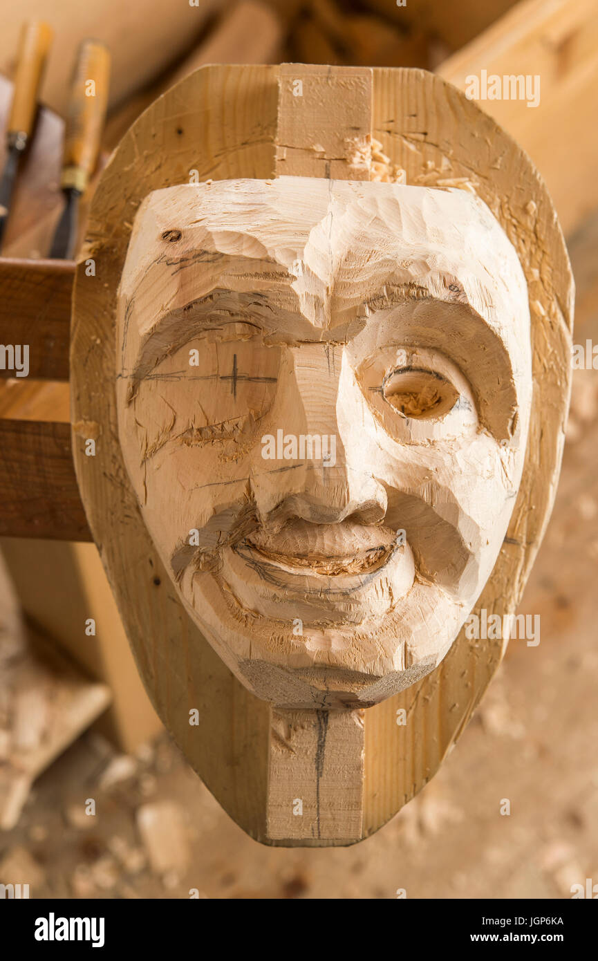 Partially shaped wooden block fixed on a workbench, unfinished wooden ...