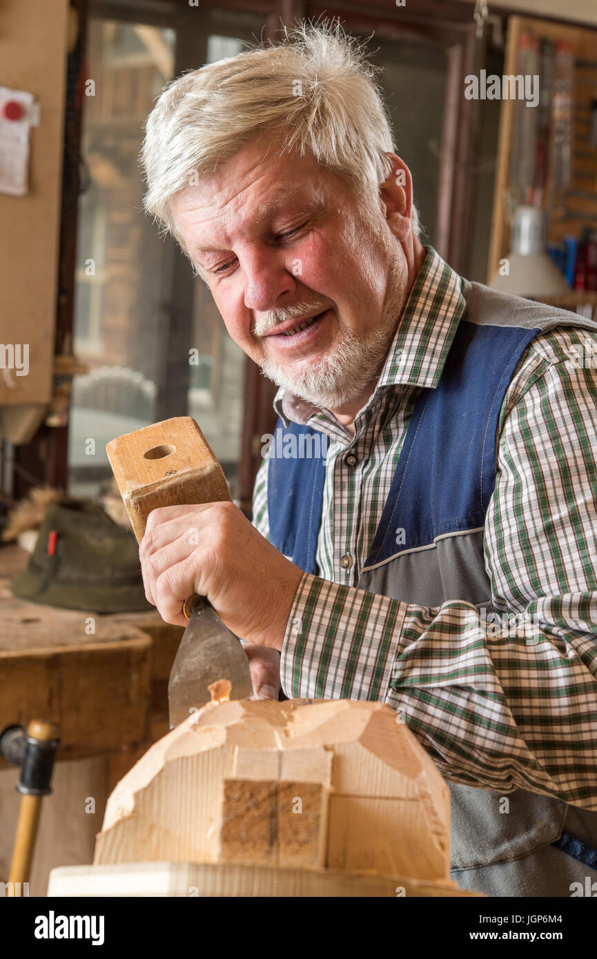 Wooden mask carver using wood carving tools on a wooden block, wooden ...
