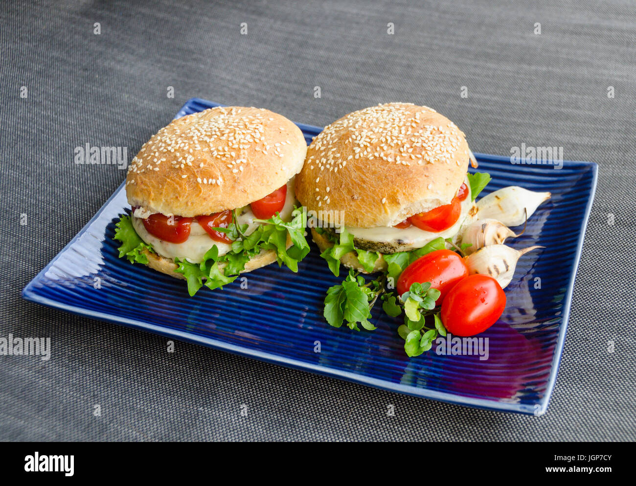 Two beluga lentils and hemp seed burgers, stacked with homegrown salad ...