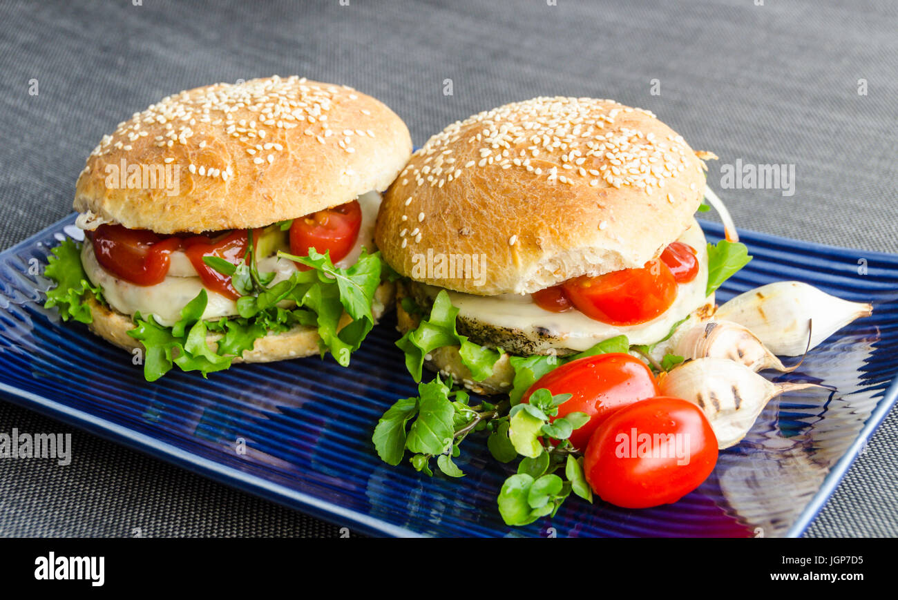 Two beluga lentils and hemp seed burgers, stacked with homegrown salad ...