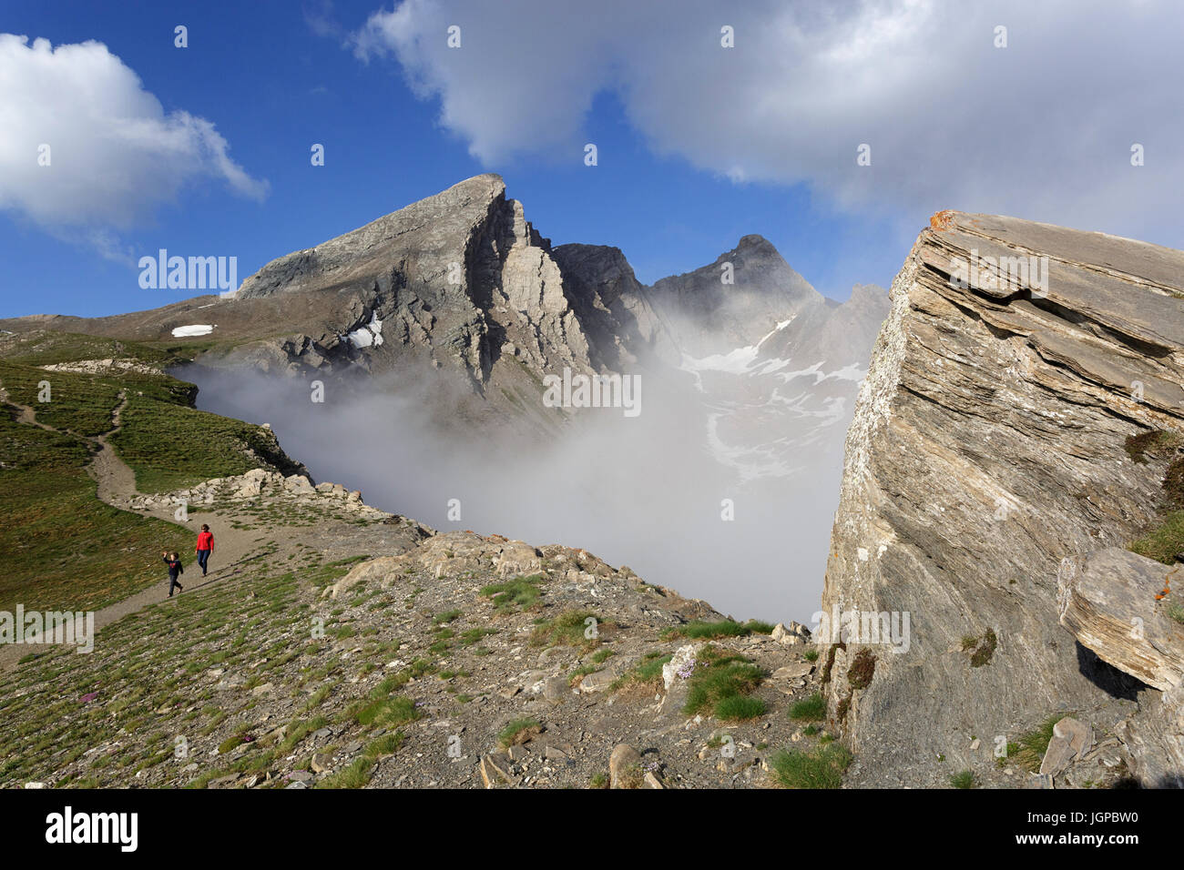 Mother and son hiking in french alps on the edge of a meadow with ...