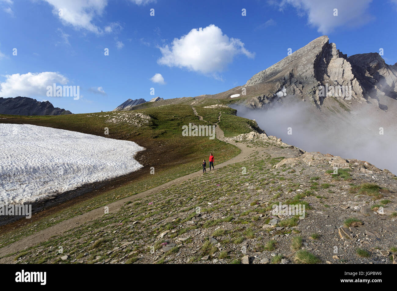 Mother and son hiking in french alps on the edge of a meadow with ...