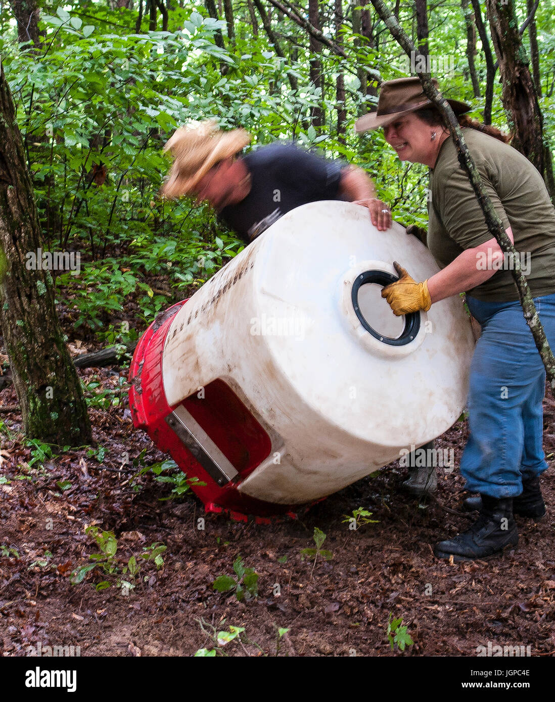 Farmers rolling water tank for farm animals, teamwork Stock Photo - Alamy