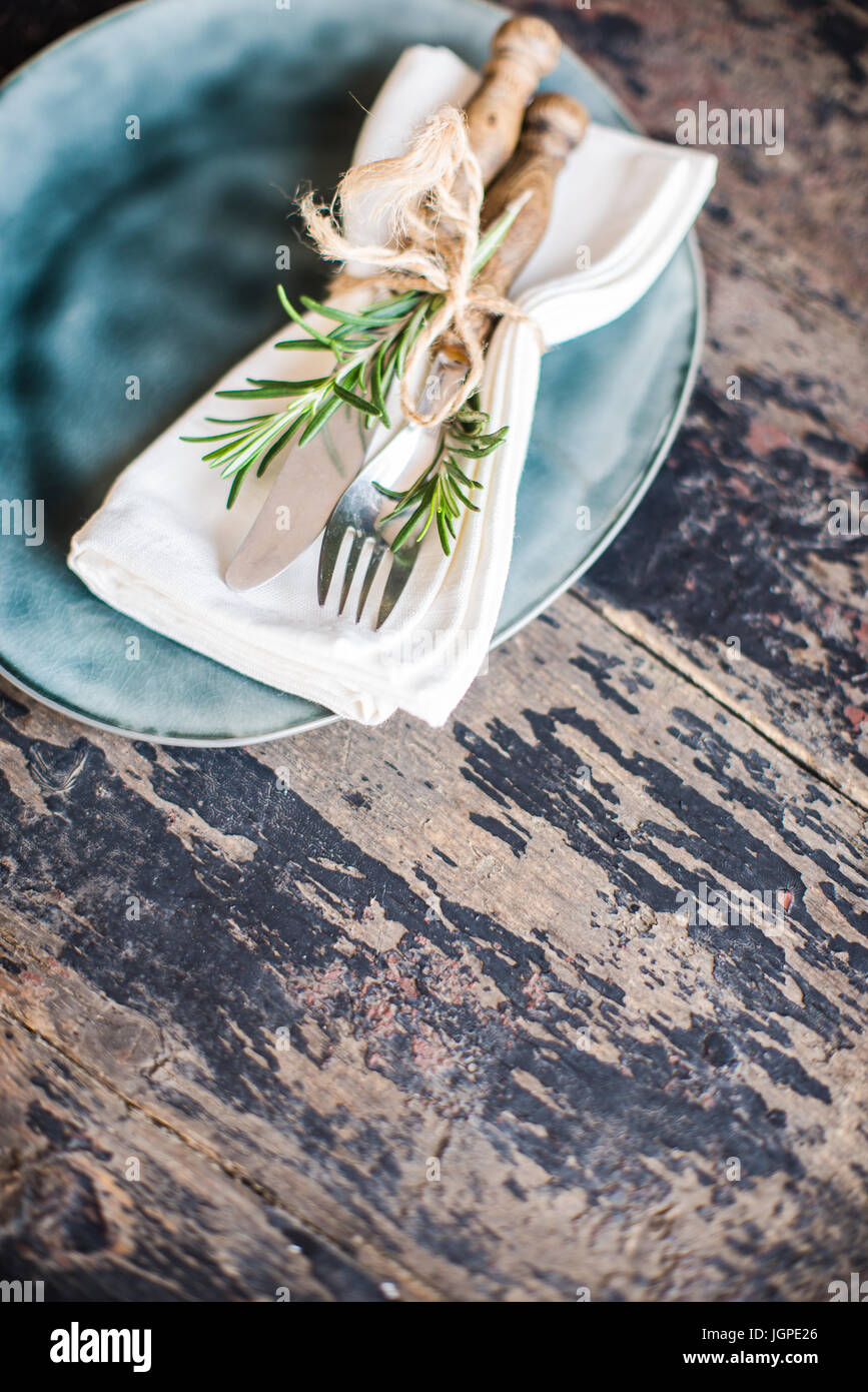 Table setting with fresh rosemary and rustic silverware on dark wooden table Stock Photo - Alamy