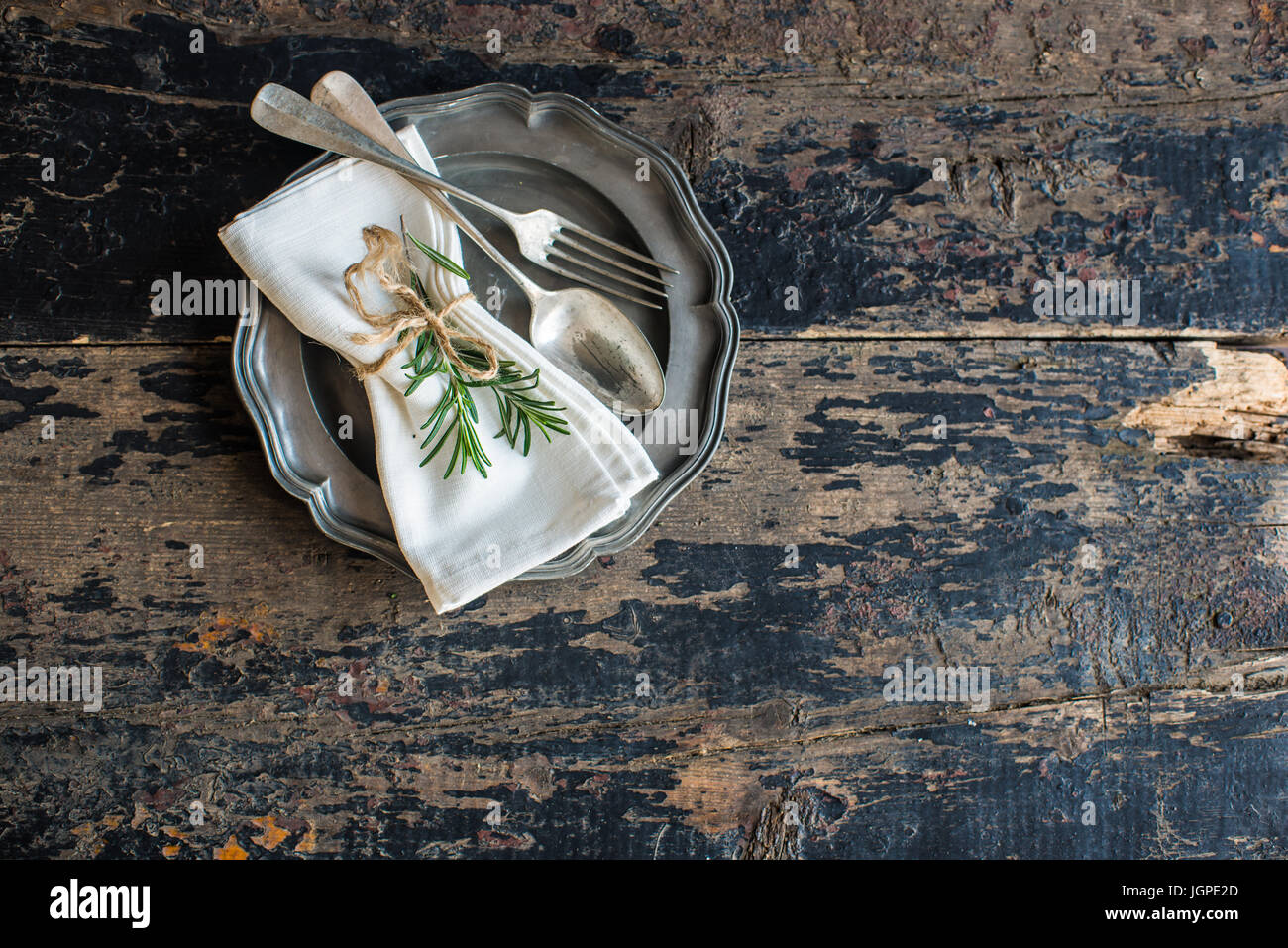 Table setting with fresh rosemary and rustic silverware on dark wooden ...
