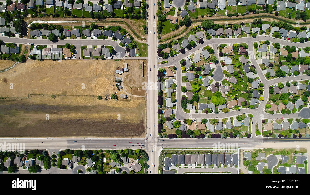 Open land in a small community with a busy street crossing Stock Photo ...