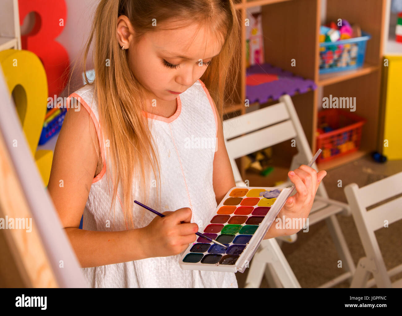 Small student girl painting in art school class Stock Photo - Alamy