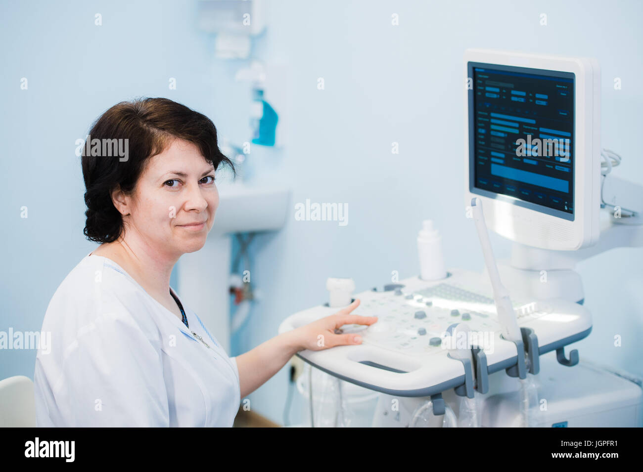 Happy mature female doctor using ultrasound scanner. Echography machine ...