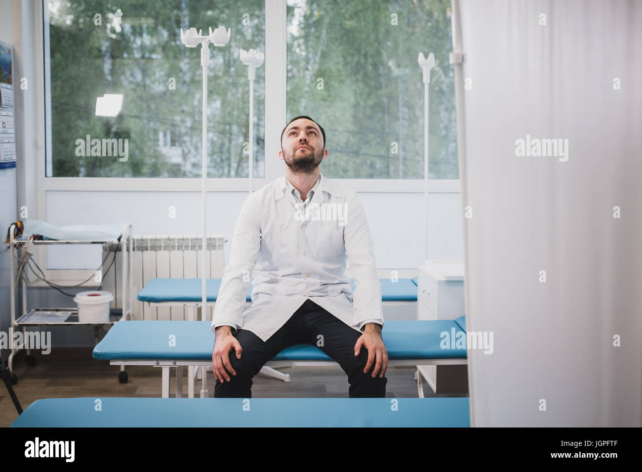 Tired doctor sitting alone in hospital ward Stock Photo - Alamy