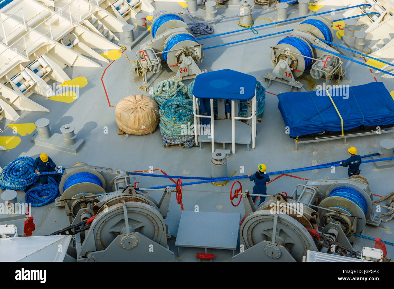 Crew members pull in the ropes securing cruise ship Vision of the Seas ...