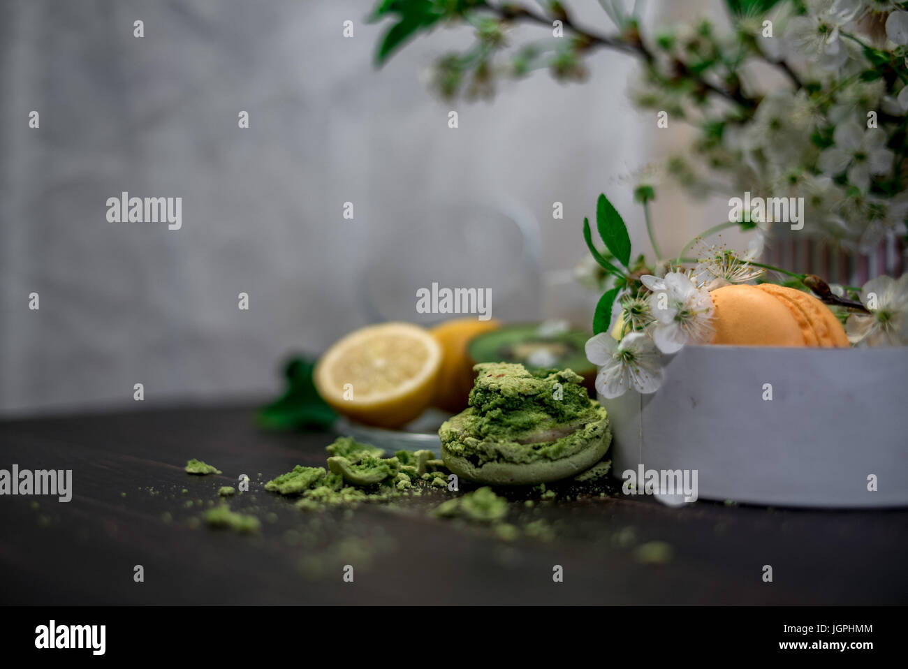 Crushed pastel, orange and green macaroons on a wood background with ...