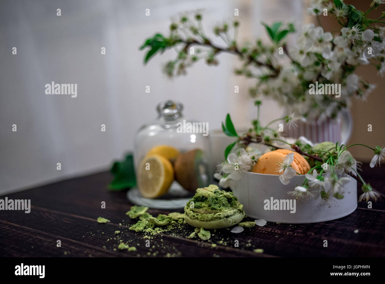 Crushed pastel, orange and green macaroons on a wood background with ...