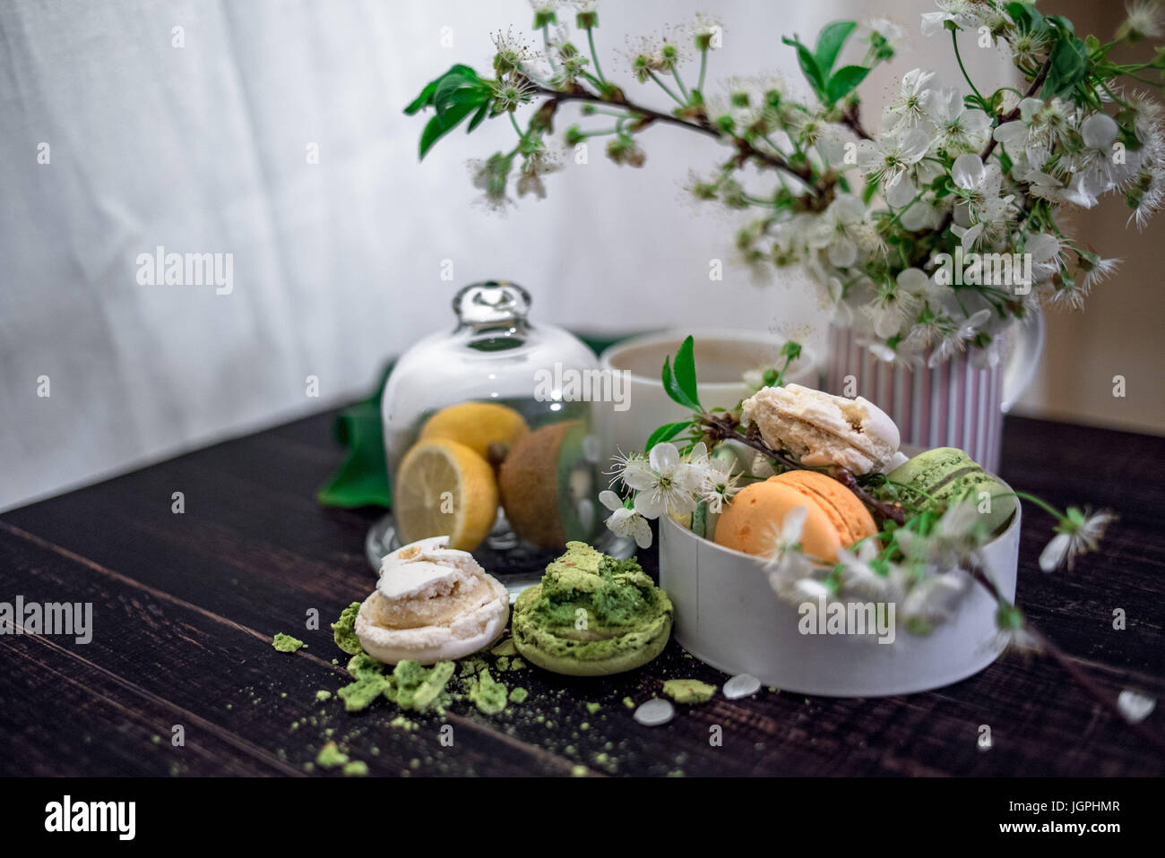Crushed pastel, orange and green macaroons on a wood background with ...
