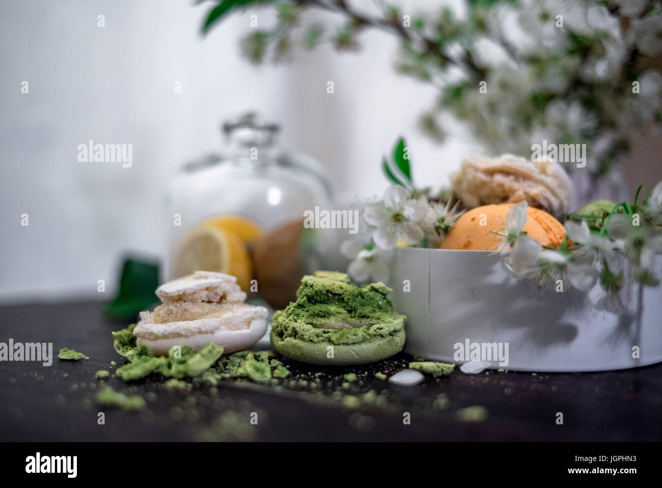 Crushed pastel, orange and green macaroons on a wood background with ...