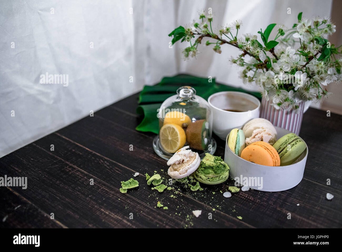 Crushed pastel, orange and green macaroons on a wood background with ...