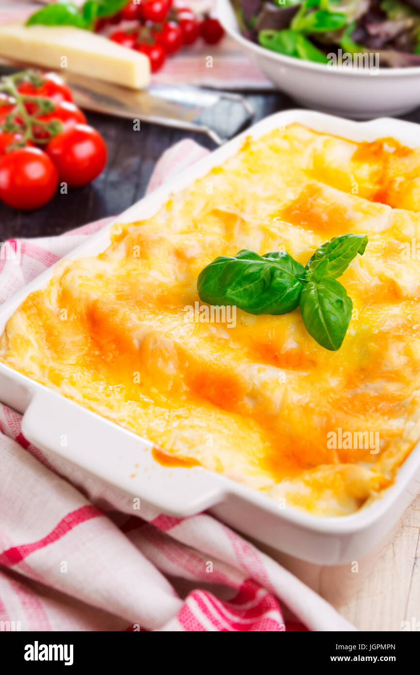 A dish with homemade lasagna on a brightly lit table Stock Photo - Alamy
